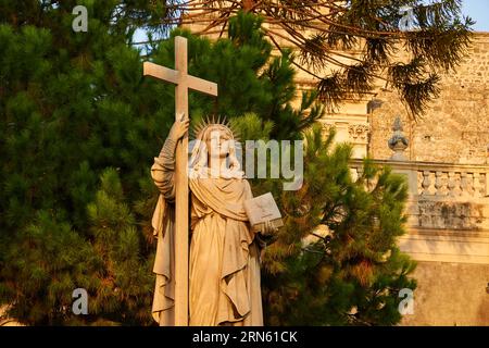 Sculpture, Fortes in Fide, with cross, church towers, evening light ...