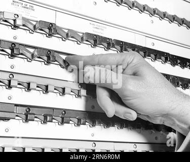 1970s MALE HAND PUSHING DOWN LEVER MAKING A SELECTION INSIDE A VOTING ...