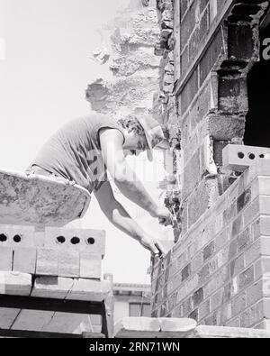 Mason bricklayer with brick. Man builder bricklayer in orange hard hat ...