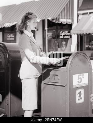 Female United States Postal Service carrier delivering mail in ...