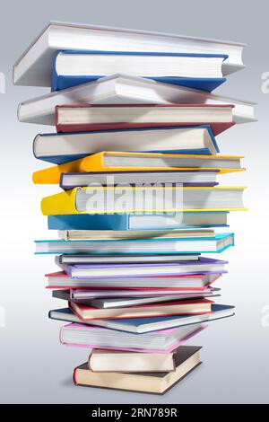stack of colored books on white desk closeup Stock Photo - Alamy