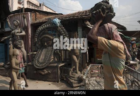 Laborers carry a clay idol of Hindu Goddess Durga to a makeshift place ...