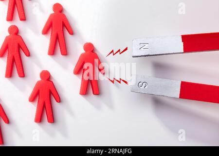 Close-up Of A Human Hand Attracting White Human Figures With Horseshoe ...