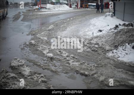 The texture of a muddy puddle with snow, ice and debris, spring ...