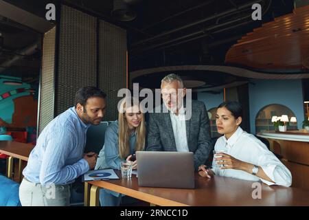 Group of people discussing daily plans in the office using laptop. Business teamwork situation ...