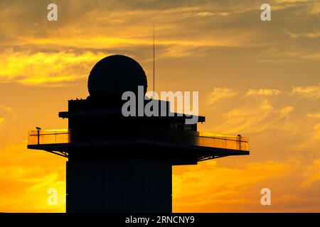 The dome of the astronomical observatory against the orange, sunset sky ...