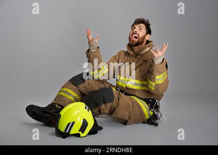 Sad, exhausted firefighter in uniform tiredly rubbing forehead in ...