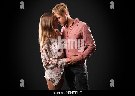 Loving soulmates stand and hold hands, with their heads together and ...