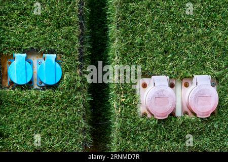 Electric sockets for charging on a pole with artificial green grass in ...