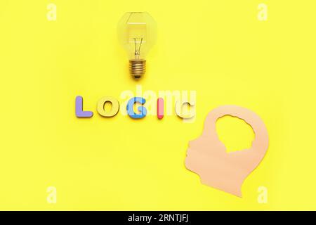 Word LOGIC, light bulb and paper human head on yellow background with ...