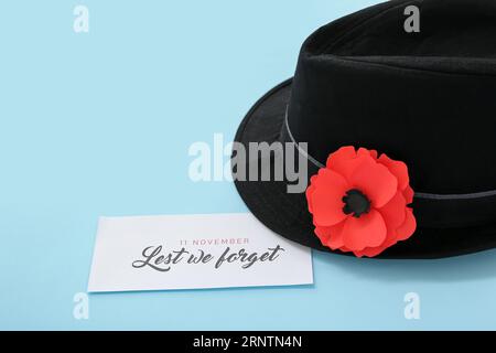 Poppy flower, hat and card with text LEST WE FORGET on blue background ...