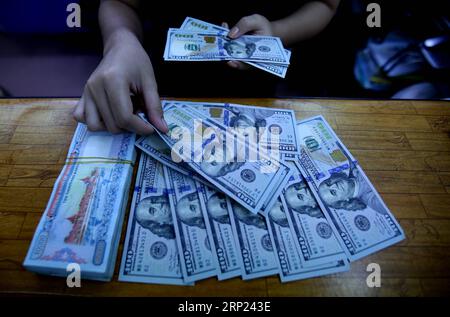180816 YANGON Aug. 16 2018 Xinhua A clerk counts U.S. dollar banknotes at a foreign currency exchange counter in Yangon Myanmar Aug. 16 2018. U.S. dollar exchange rate rose sharply
