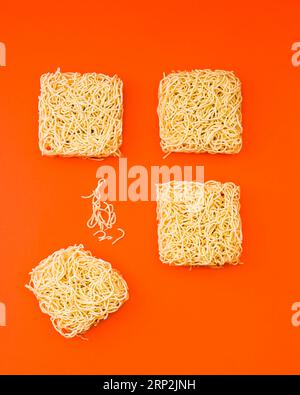 Dried instant noodle blocks arranged orange backdrop Stock Photo - Alamy