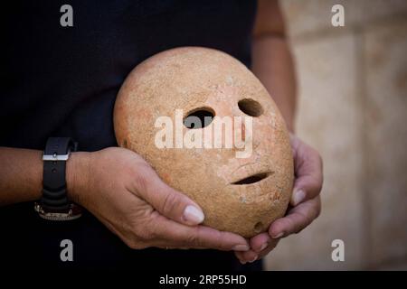 A mask from the Neolithic period ( 9,000 years ago) is displayed in the ...