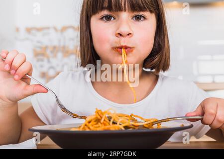 cute girl eating delicious pasta kitchen. High resolution photo Stock ...