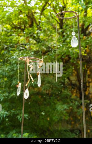 Group of white quartz crystals hanging on strings over nature ...