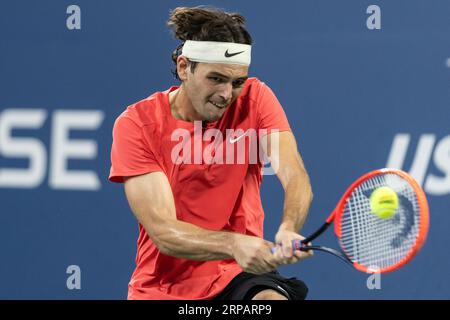Dominic Stricker of Switzerland, returns a ball to Cameron Norrie of ...