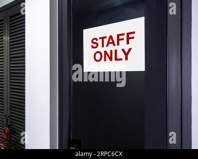 Red and white 'Staff Only' sign with bilingual text in English and ...