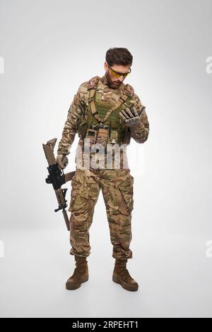 Wounded military infantry in body armor checking chest, if there any ...