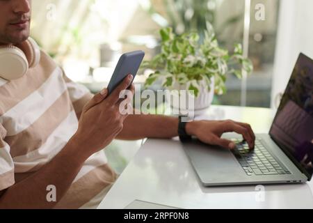 Male freelancer using mobile device for video call with friends during ...