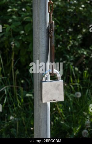 Heavy padlock hanging from steel beams of an industrial bridge Stock ...