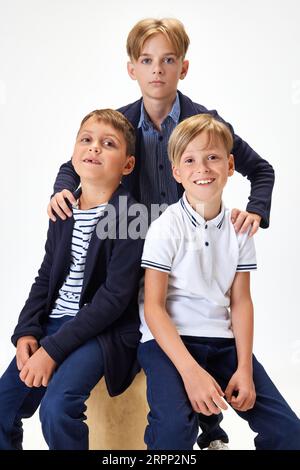 Boys, children, classmates in stylish school uniform against white ...