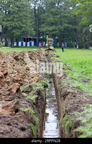 Small excavator digging a trench ditch for a building foundation Stock ...