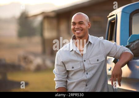 Portrait Of Man Loading Backpack Into Pick Up Truck For Road Trip To ...