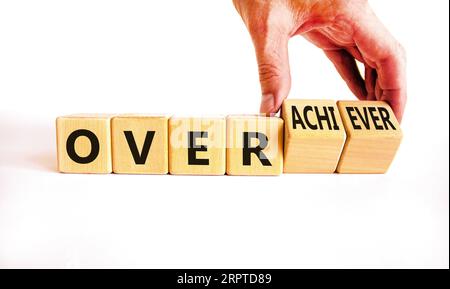 Achiever or overachiever symbol. Businessman turns wooden cubes and ...