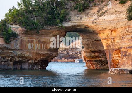 Catamaran viewed through a natural arch along Pictured Rocks National ...