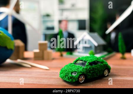 EV car model on table with blurred business people planning business ...