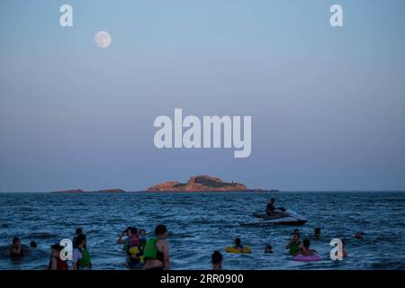 200803 -- ZHOUSHAN, Aug. 3, 2020 -- Tourists view illuminated sand ...