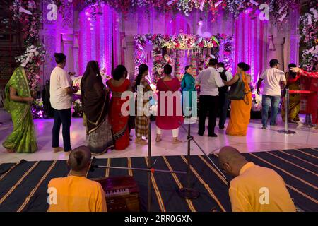Hare Krishna devotees queue to pray in front of an altar at ISCKON ...