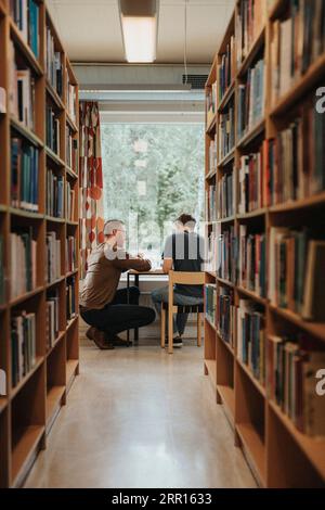 Professor explaining student in library at university Stock Photo - Alamy
