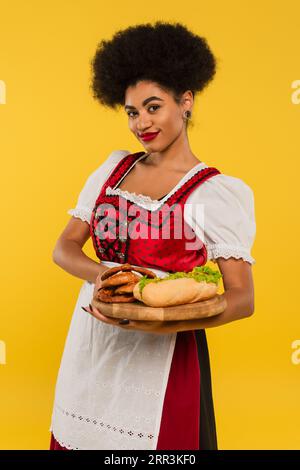 charming african american oktoberfest waitress looking away with hands ...