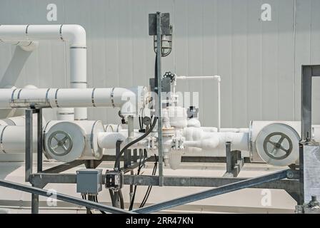 White insulated piping mounted on roof of cold storage facility, for ...
