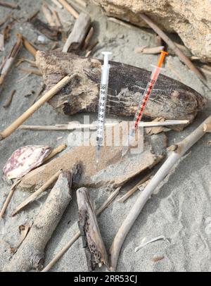 two used disposable syringes abandoned on the sandy beach Stock Photo ...