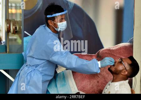 (210324) -- DHAKA, March 24, 2021 (Xinhua) -- A man and a child wait ...