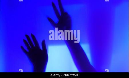 A horror concept of spooky ghostly hands coming out of the base of a ...