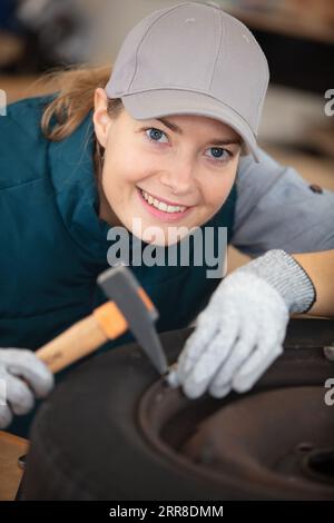 Female auto mechanic using hammer in car repair garage Stock Photo - Alamy