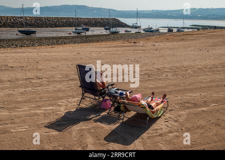 Sunbathers at Colwyn bay harbour in North Wales Stock Photo - Alamy