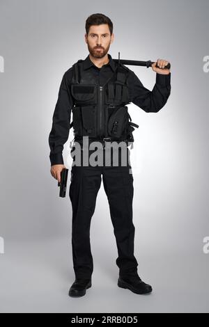Male police officer with baton on white background Stock Photo - Alamy