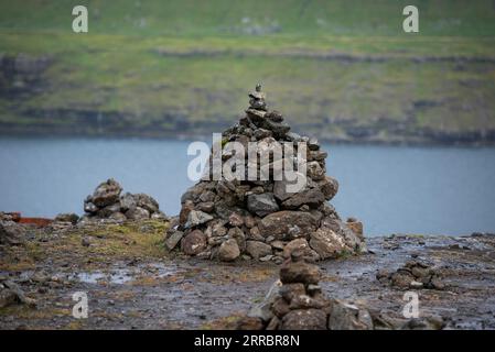 Rock cairns sit atop a stretch of open bedrock on Streymoy island in ...