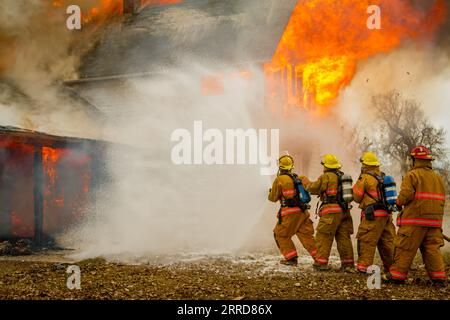 four firefighters advancing on a fire Stock Photo - Alamy