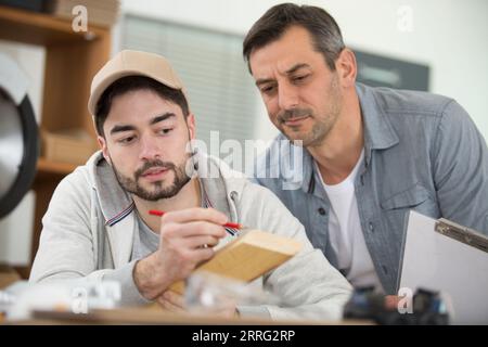 Two young workers or craftsman apprentices work together in the workshop Stock Photo - Alamy
