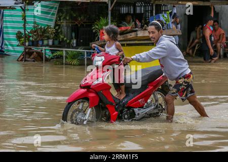 220926 -- BULACAN, Sept. 26, 2022 -- Residents wade through a flooded ...