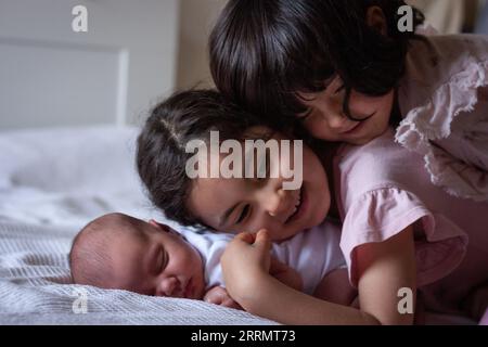 pyramid of three smiling girls lying on each other Stock Photo - Alamy