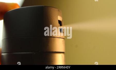 Someone spraying deodorant out of black deodorant can Stock Photo - Alamy