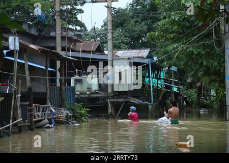 230812 -- BAGO, Aug. 12, 2023 -- A man sits on a floating tube in flood ...