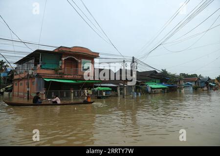 230812 -- BAGO, Aug. 12, 2023 -- A man sits on a floating tube in flood ...